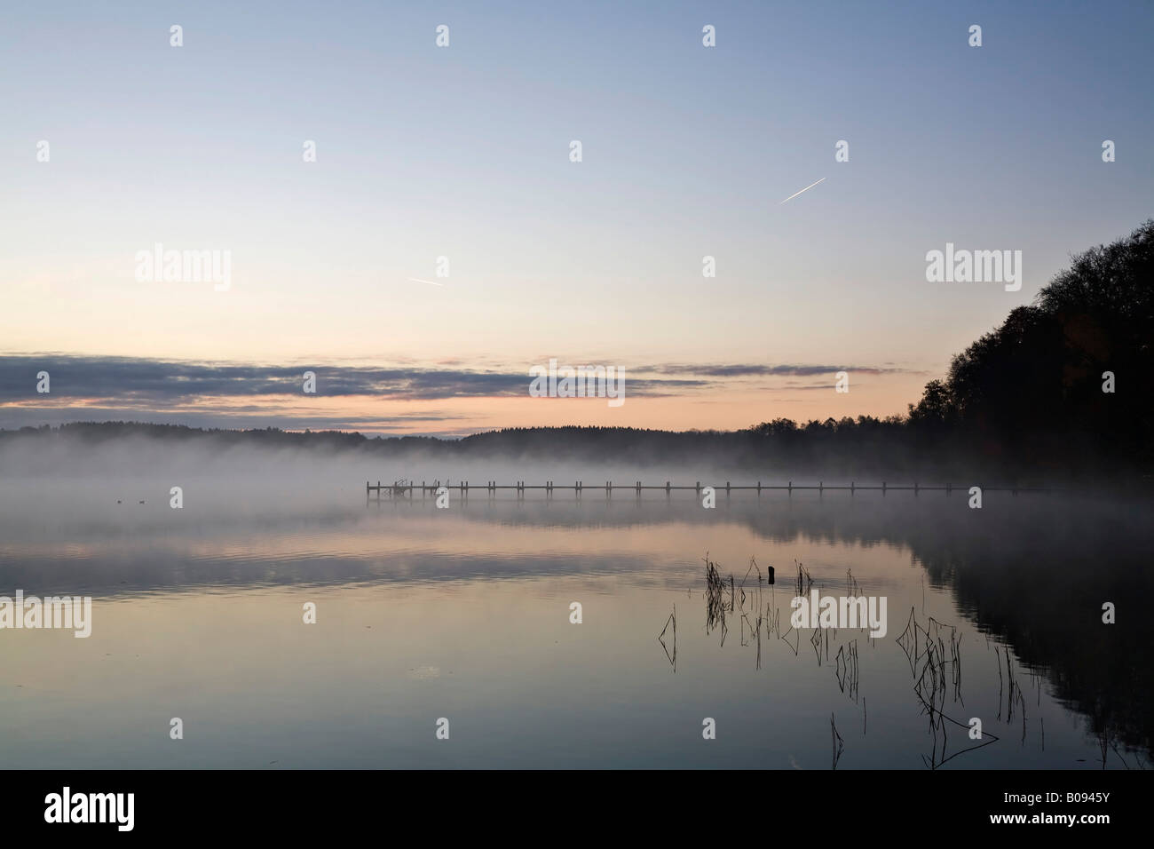 Light fog over Lake Woerthsee at dawn, wooden dock, Bavaria, Germany ...
