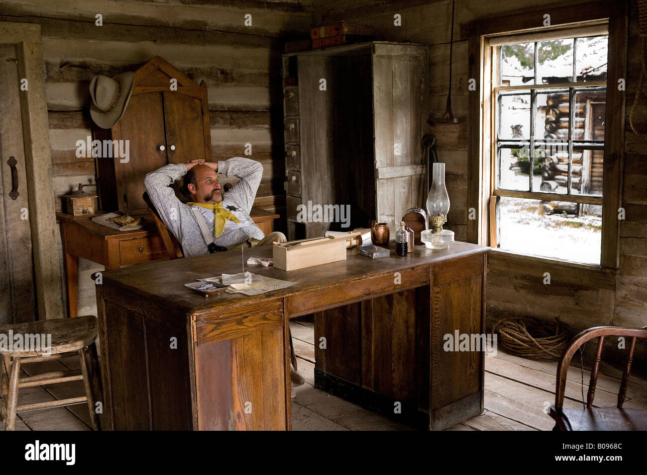 Image of the town sheriff sitting at his desk looking out the window ...