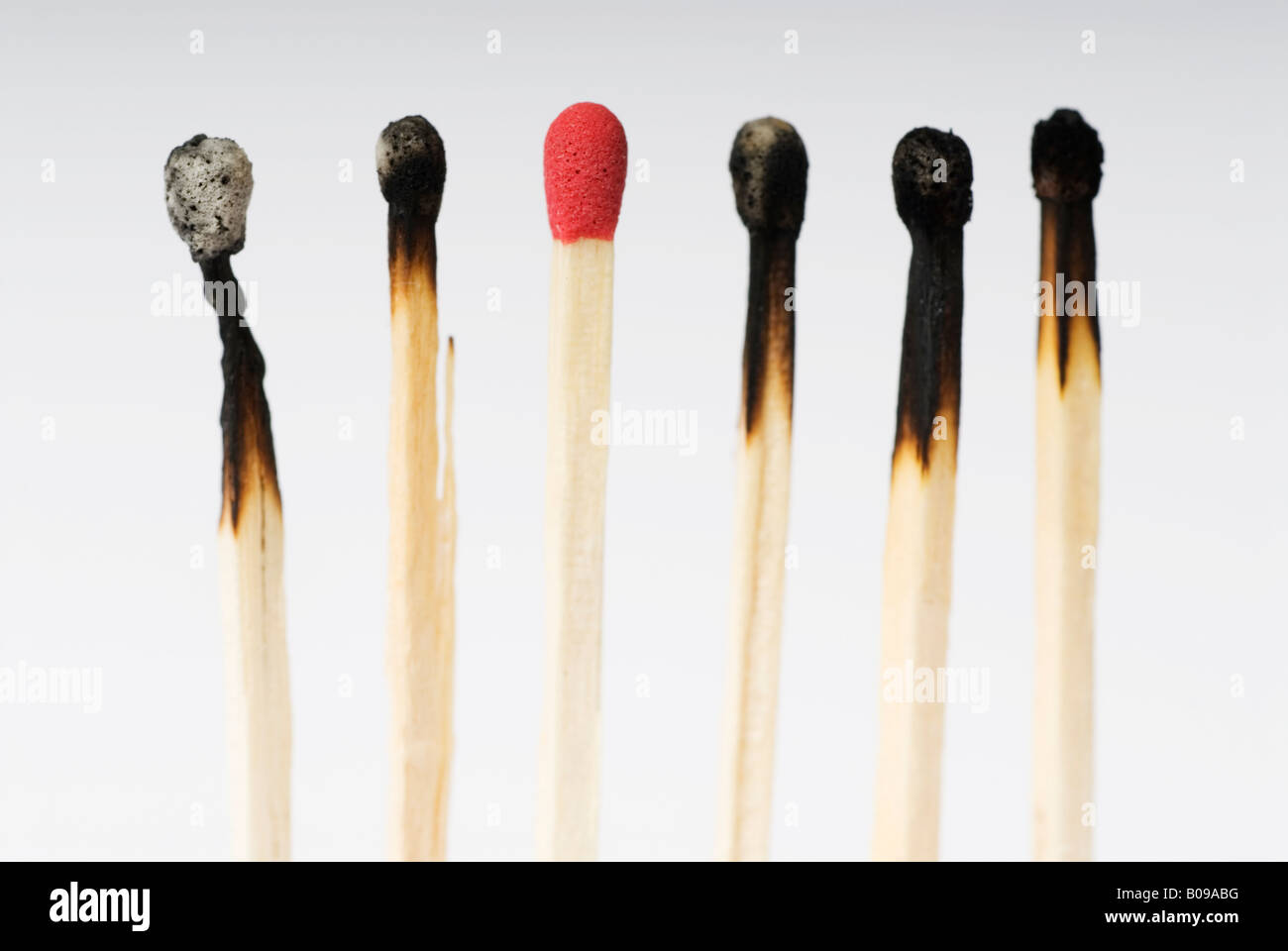 Stock photo of a live red match head next to an old burnt out match ...