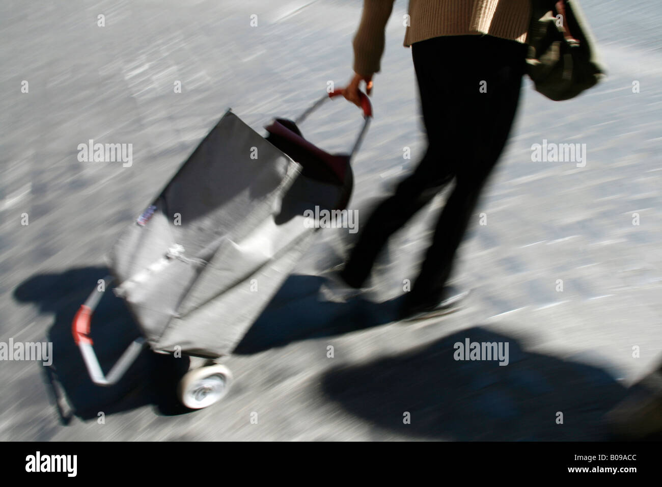 woman pulling shopping trolley in street Stock Photo - Alamy