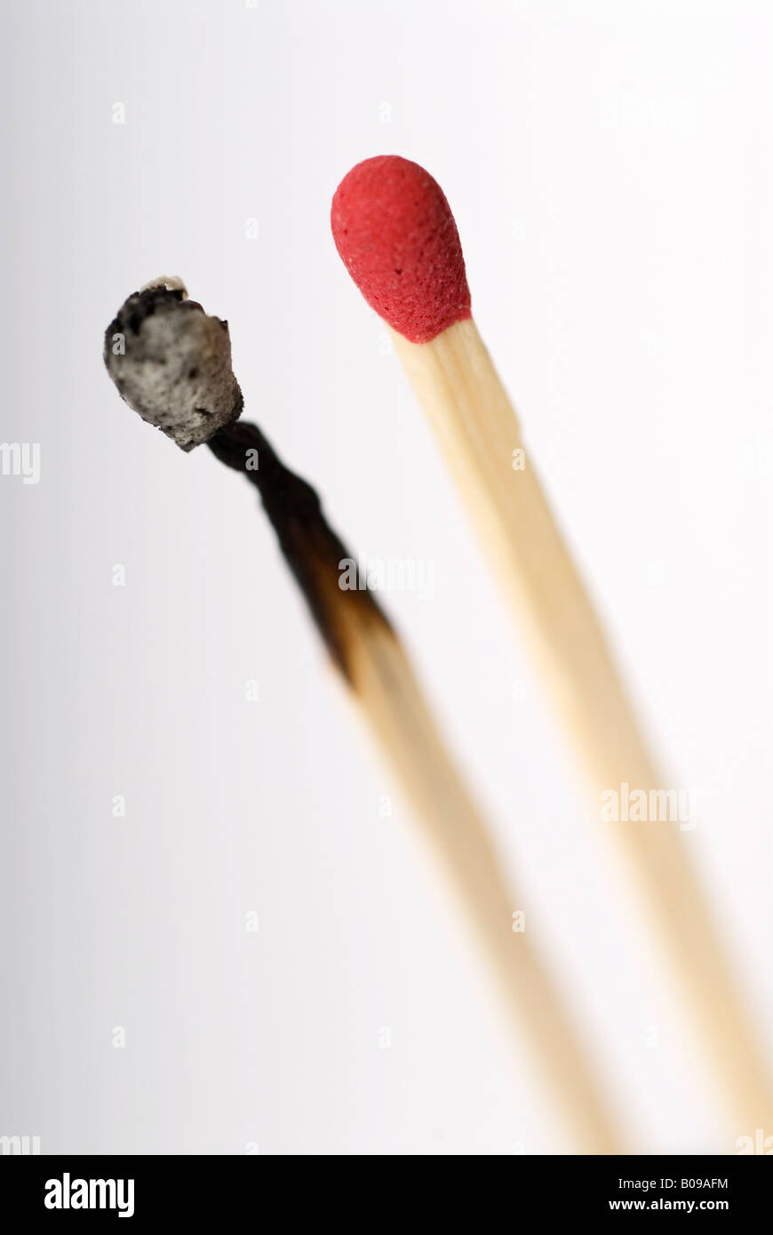 Stock photo of a live red match head next to an old burnt out match ...
