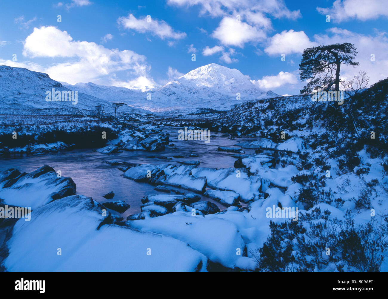 Snow covered boulders in river Glen Torridon Beinn Eighe National ...