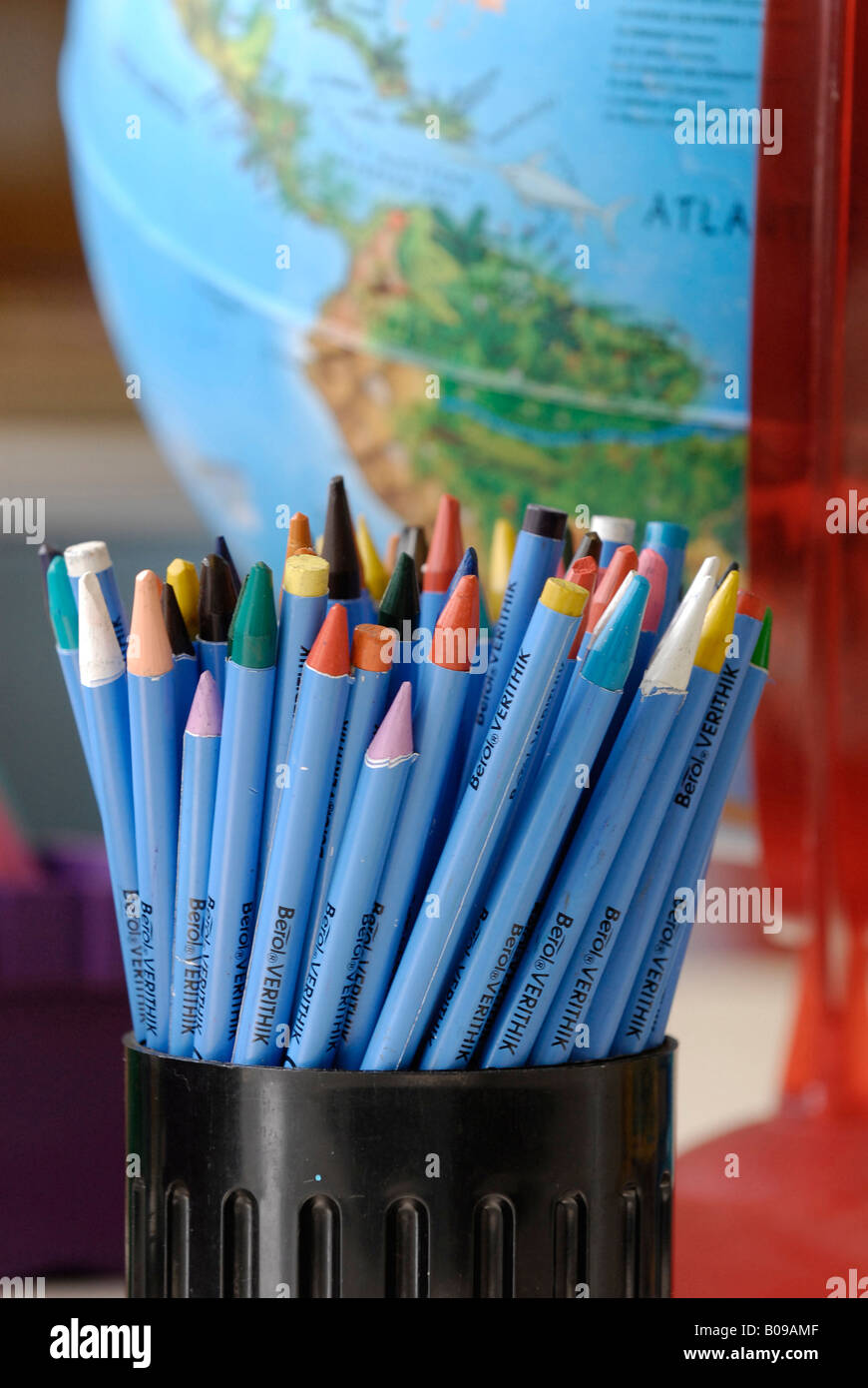 Close-up of crayons in classroom in front of a world globe Stock Photo ...
