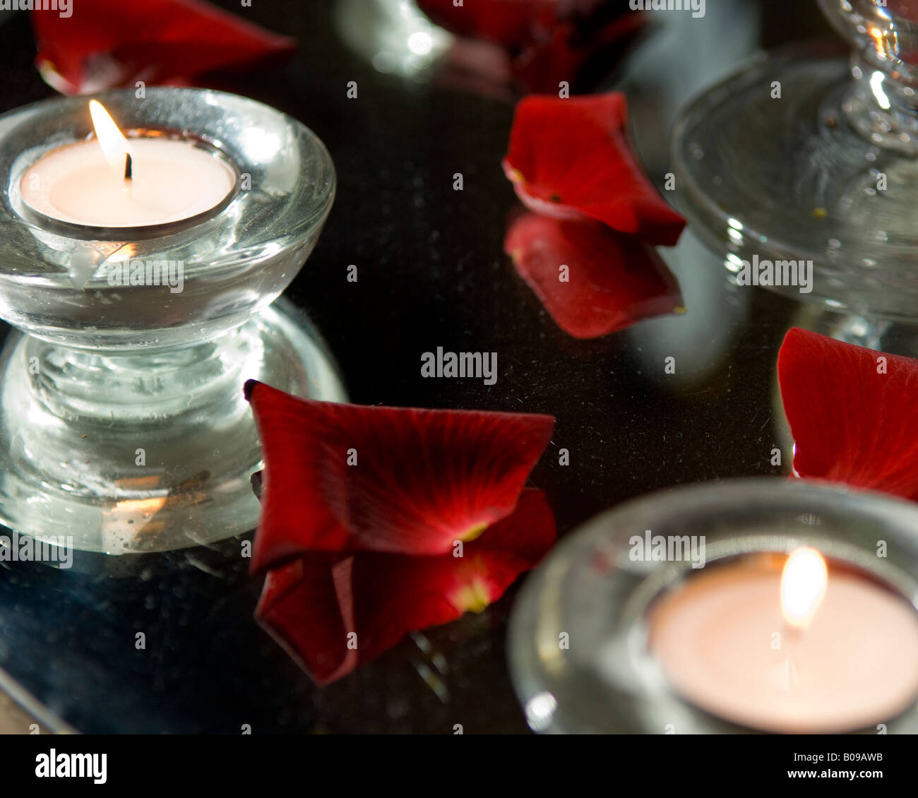 Glass table with tea lights and rose petals Stock Photo - Alamy