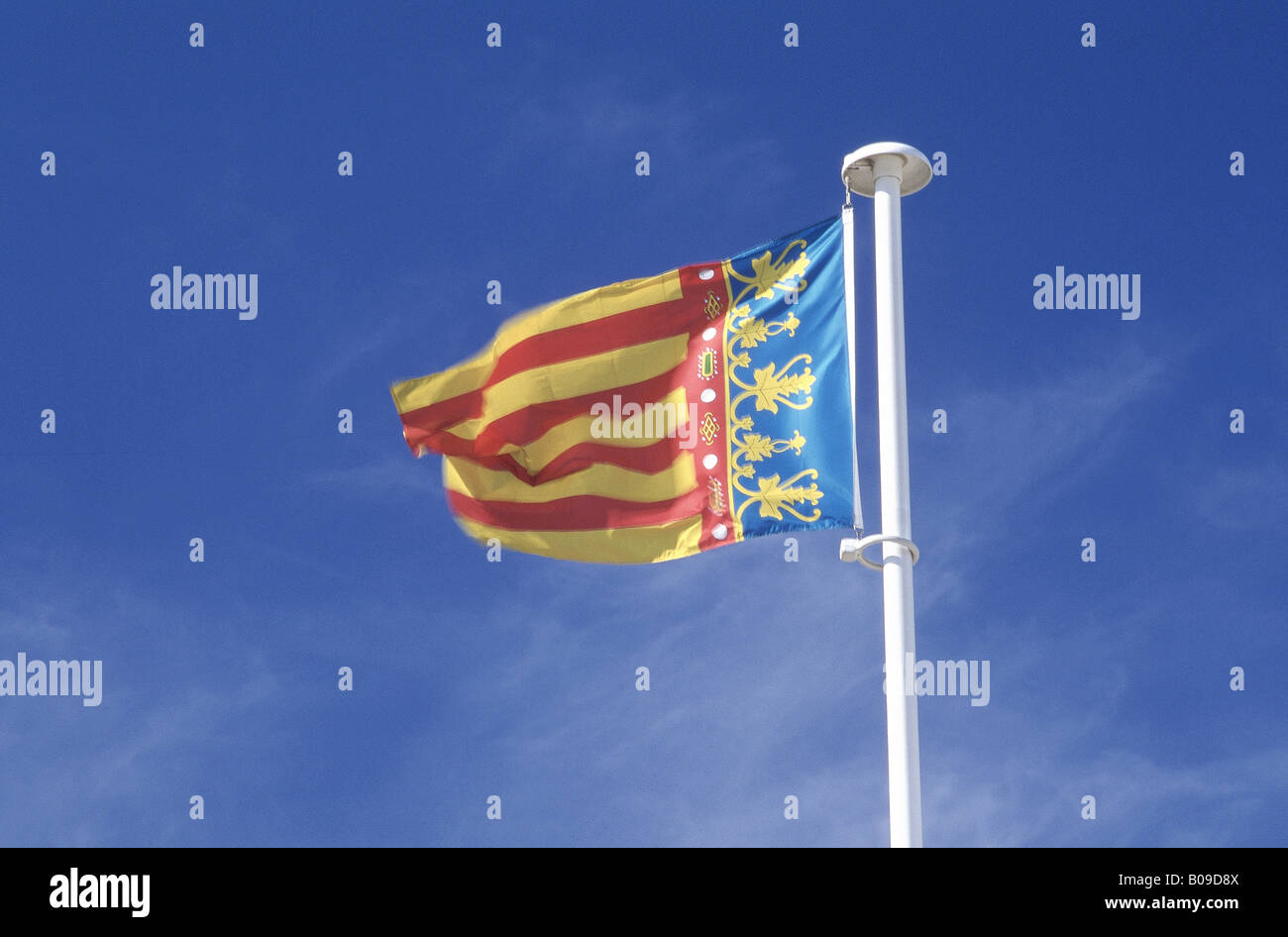 Valencian flag Red yellow stripes Blue panel Flying against blue sky ...