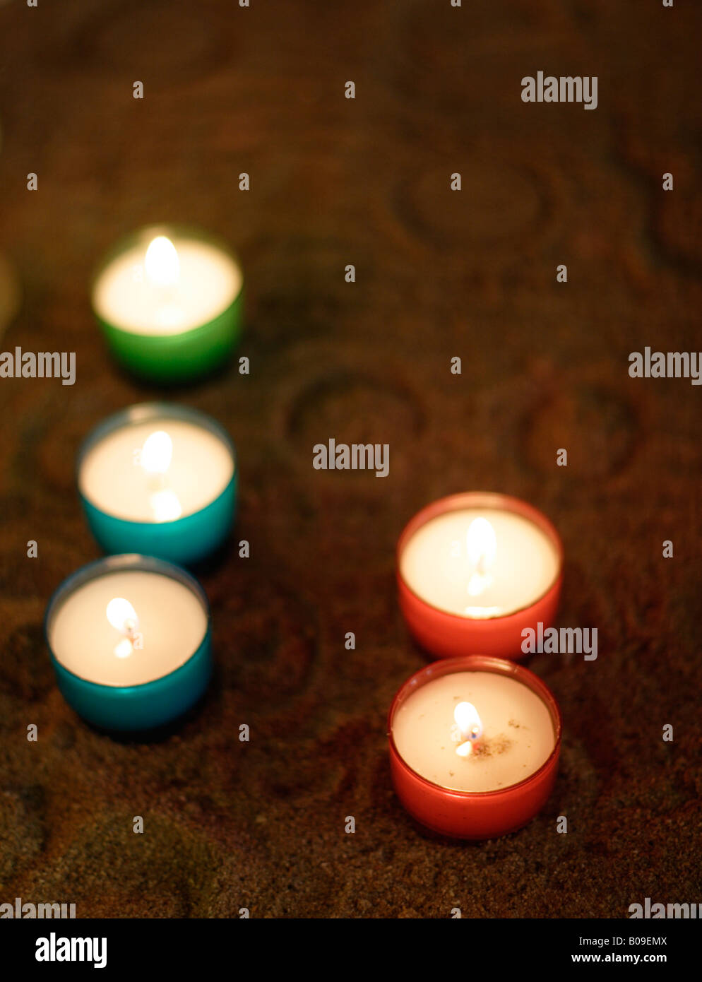 Five coloured lit church candles Stock Photo - Alamy