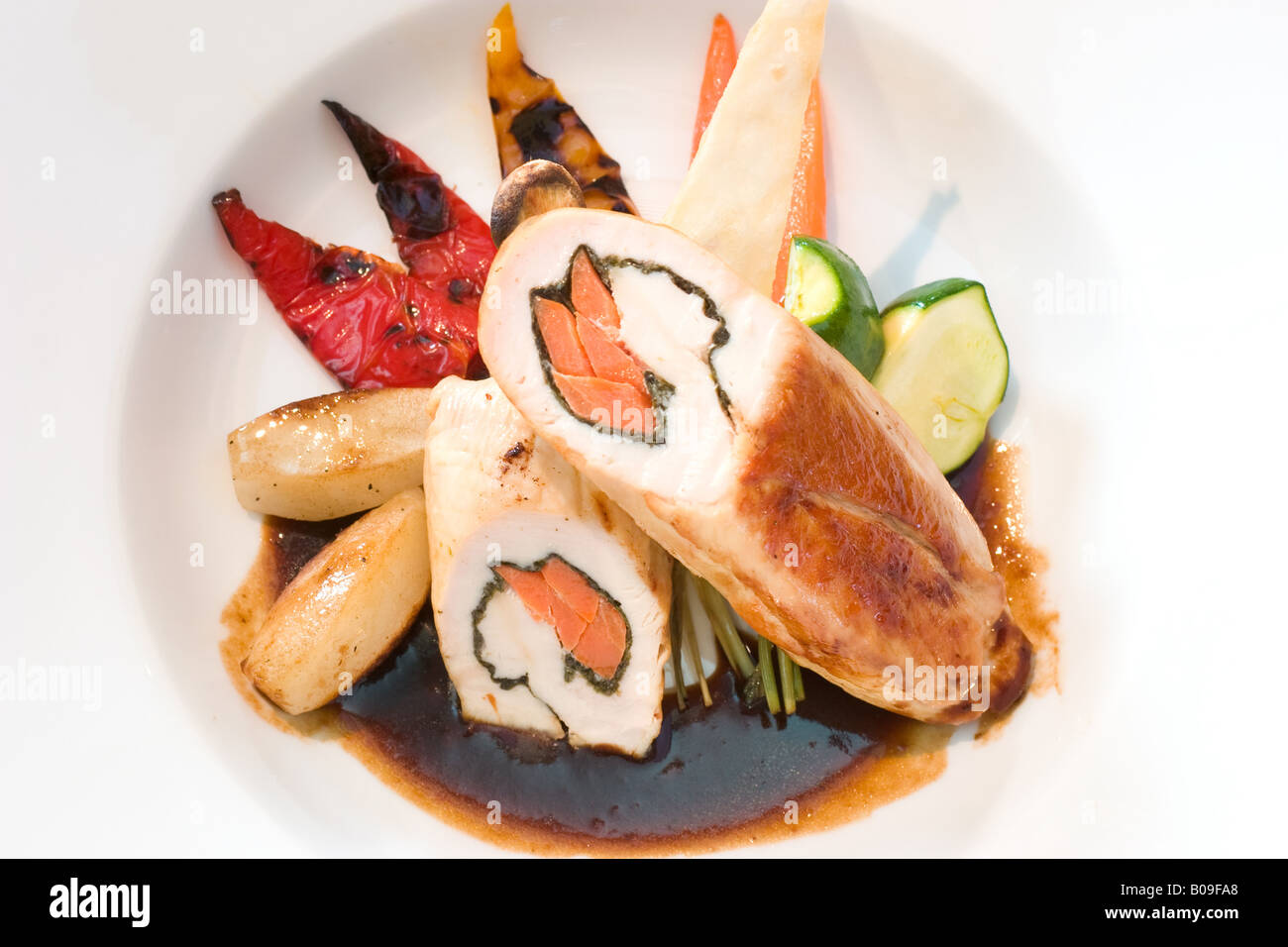 Exotic dish of stuffed turkey served with peppers potatoes and carrots ...