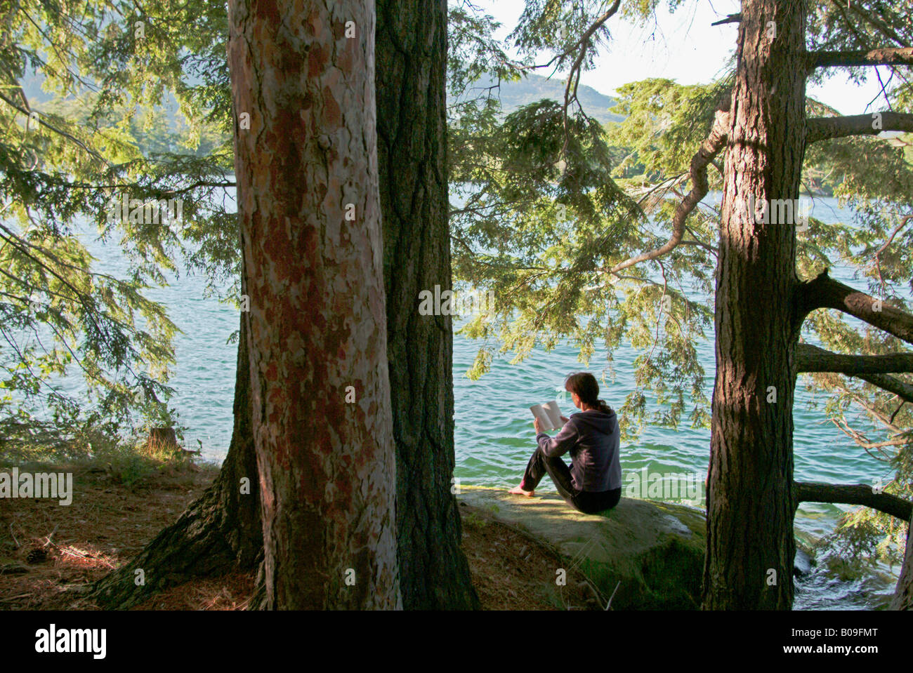 woman reading on vacation by lake Stock Photo - Alamy