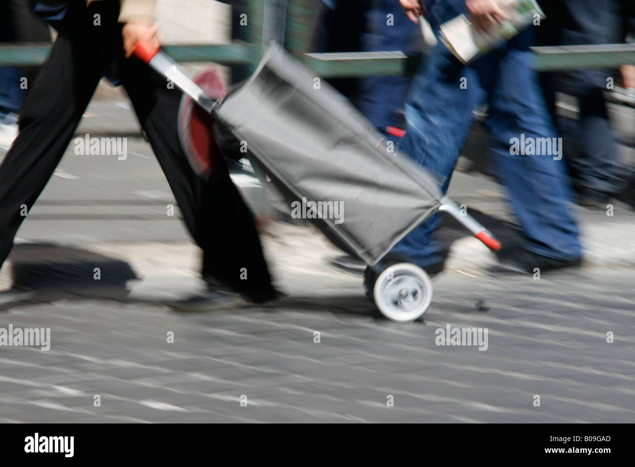 woman pulling shopping trolley in street Stock Photo - Alamy
