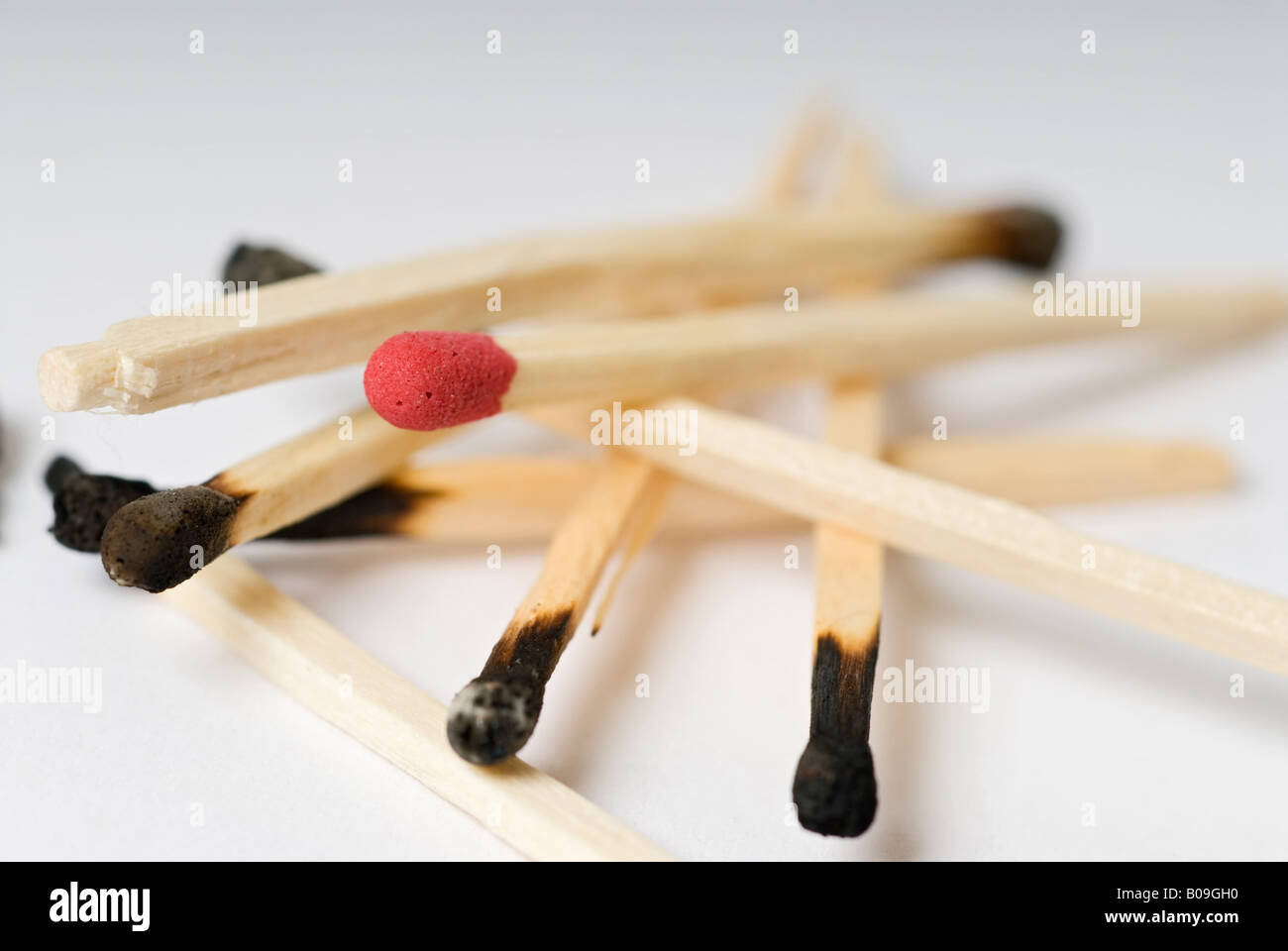 Stock photo of a live red match head next to an old burnt out match ...