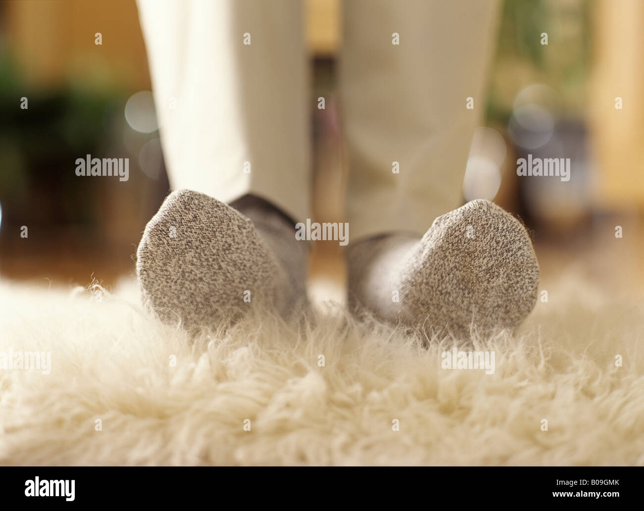 A photo of feet in fuzzy socks on top of a fur rug Stock Photo - Alamy