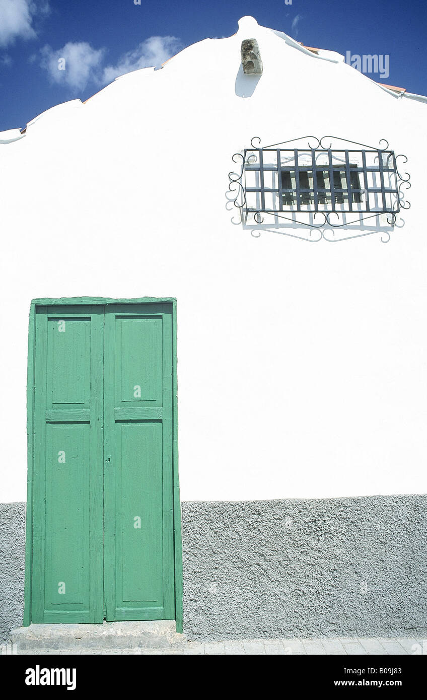 White washed building house with green door Wrought iron over small ...