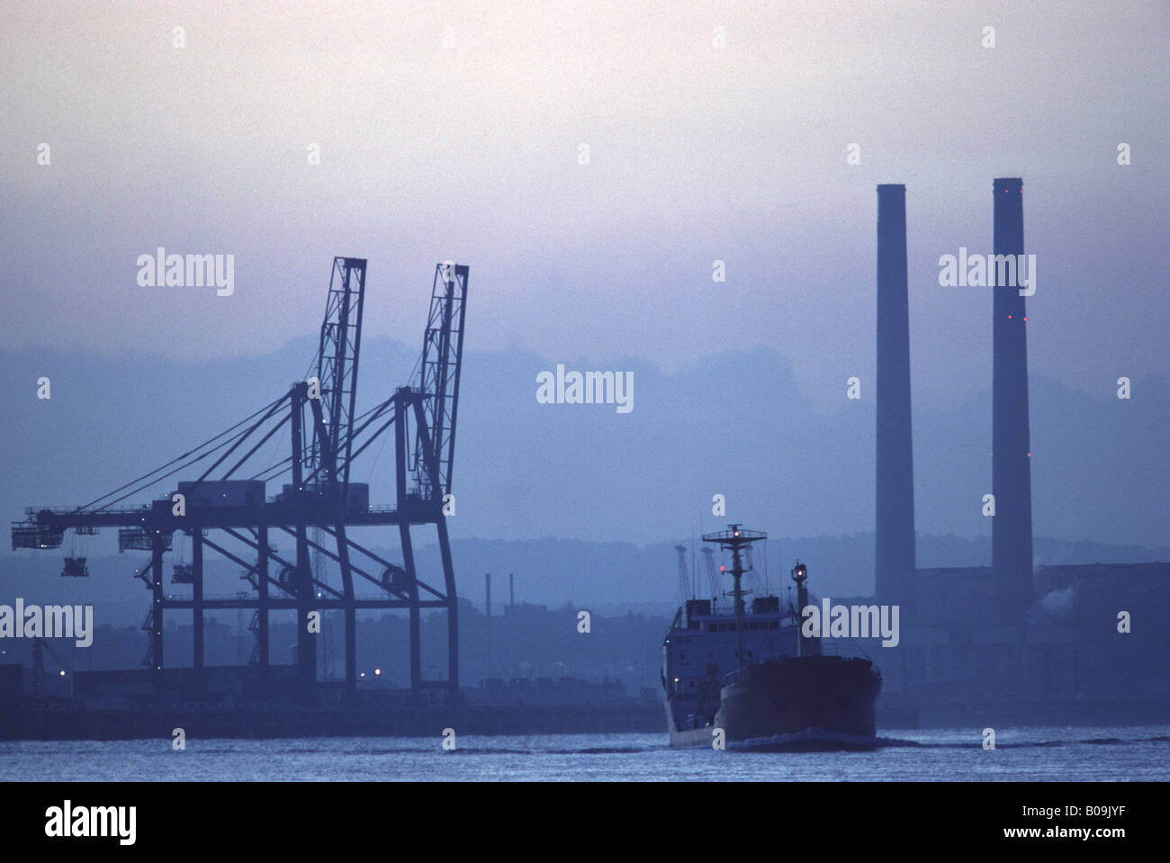 Freighter navigating the River Thames near Tilbury Docks. Early morning ...