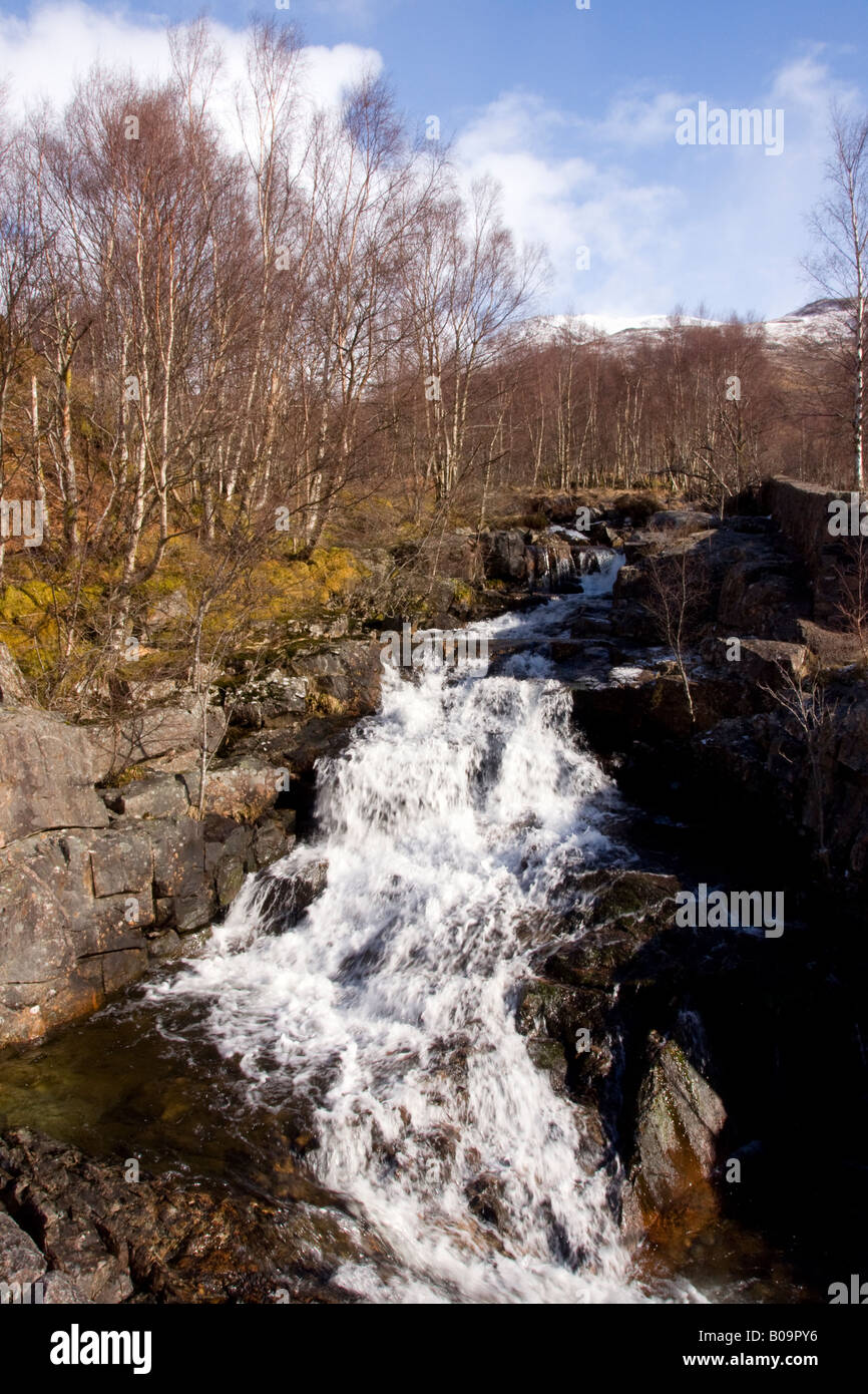 scottish mountain stream and waterfall five sisters area with snow on ...