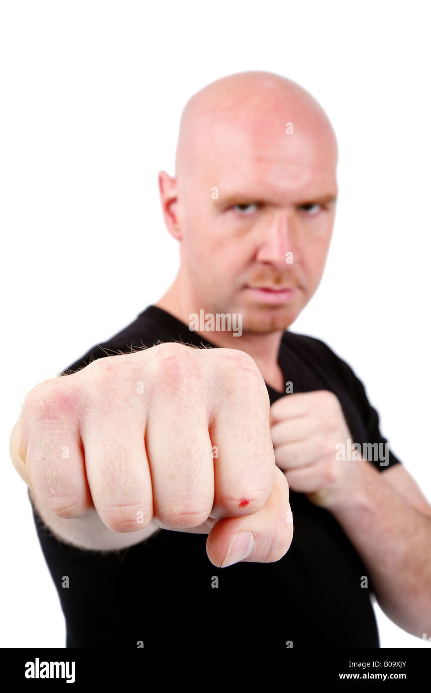 bald headed, young mean man threatening with his fist Stock Photo - Alamy