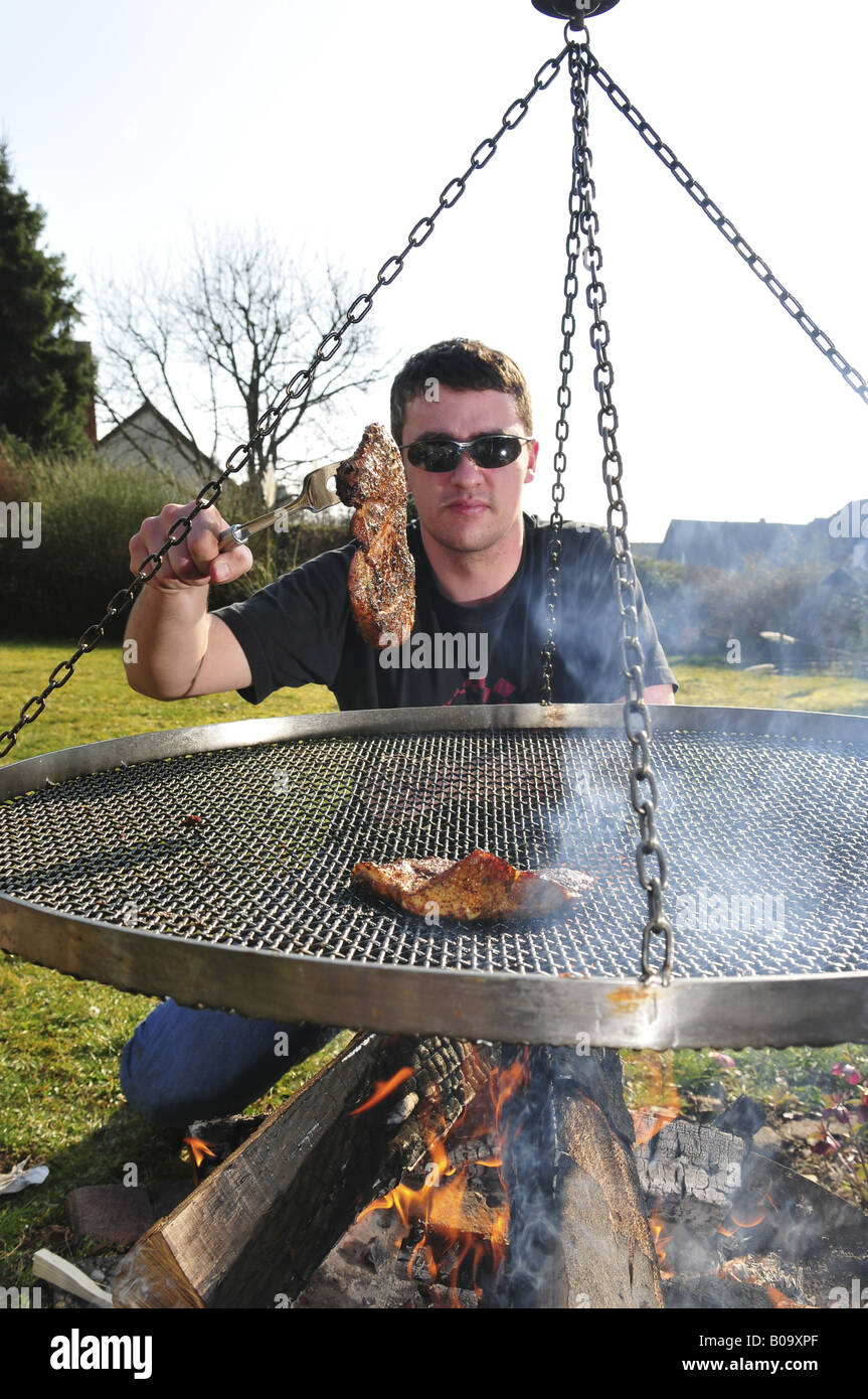 Schwenker. Man grilling meat Stock Photo - Alamy