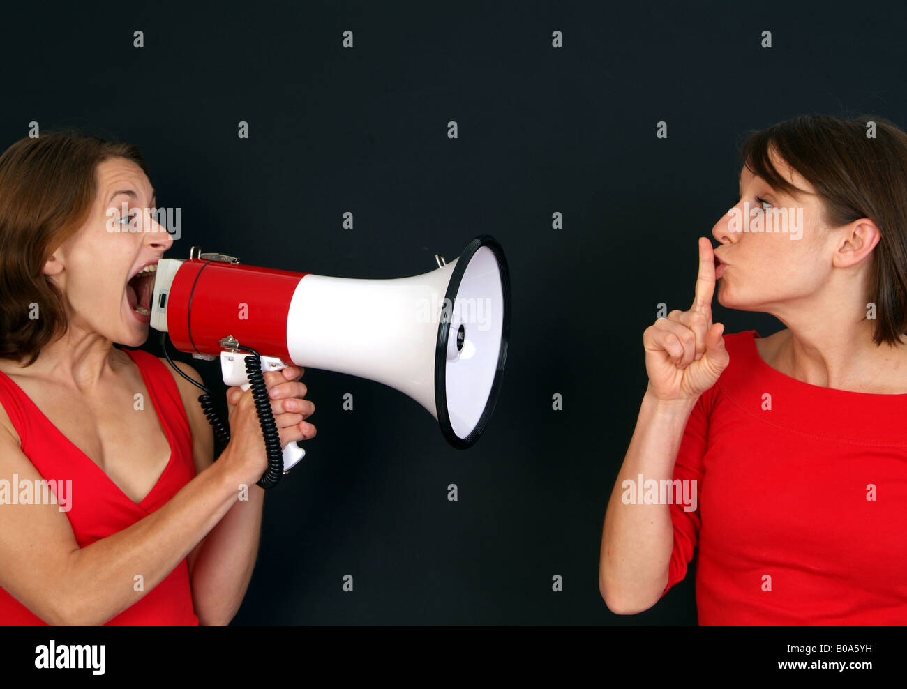 woman screaming in megaphone, other woman wants her to quiet down Stock ...