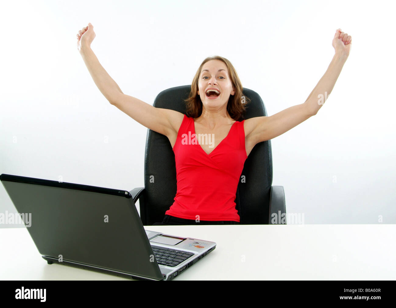 young cheering woman in a red dress working with a laptop Stock Photo ...