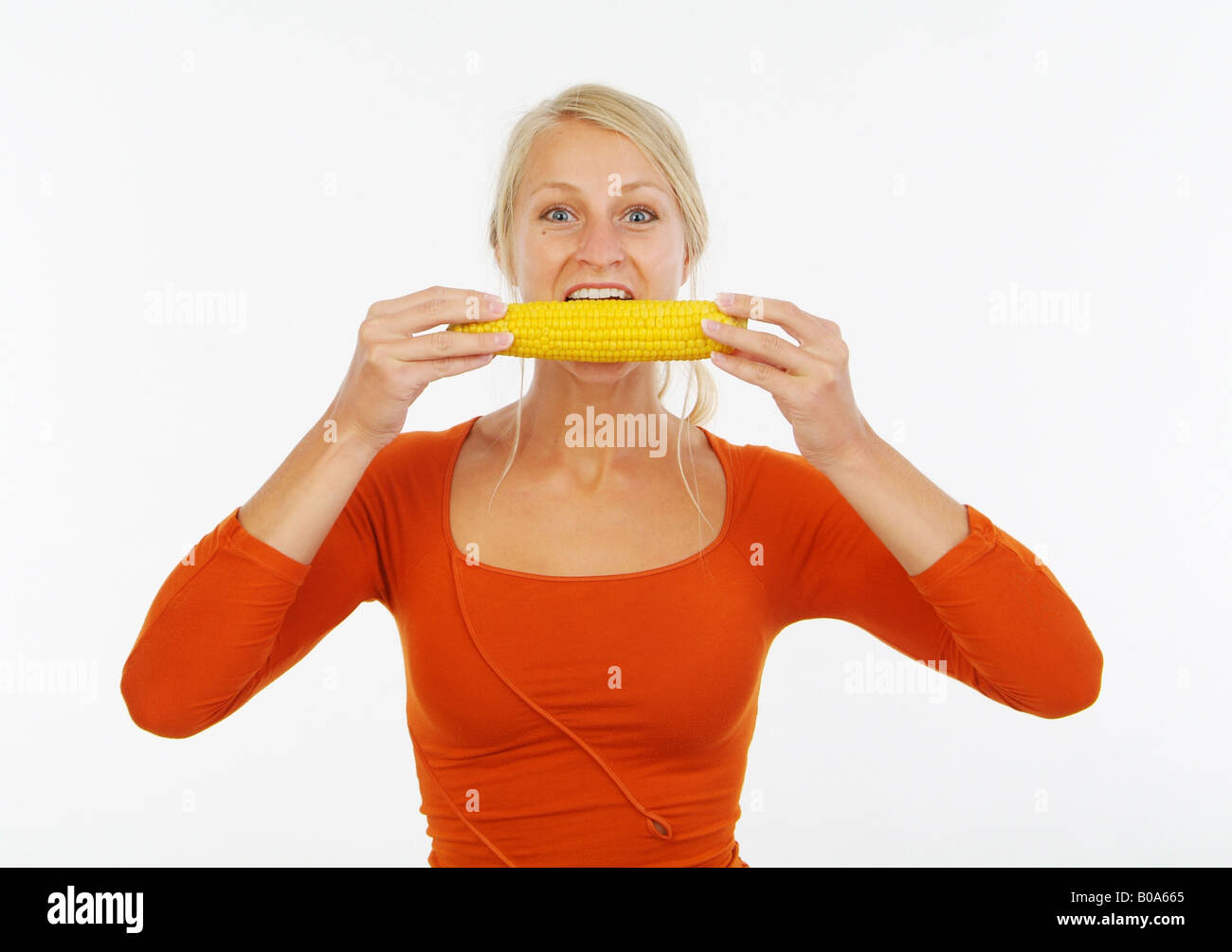 young blond woman eating a cooked maize cob Stock Photo - Alamy