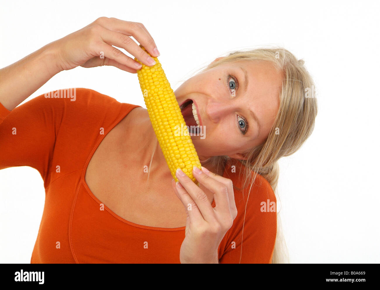 young blond woman eating a cooked maize cob Stock Photo - Alamy