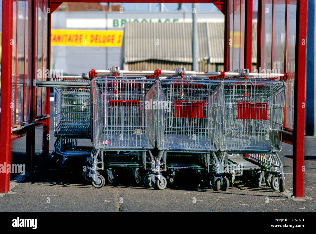 Grocery shopping carts lined up in a sheltered area outside a store ...