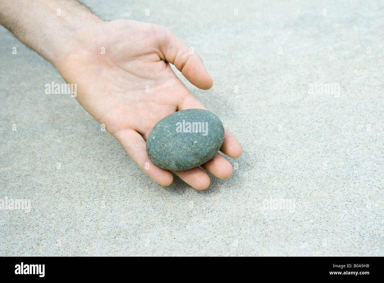 Man holding pebble in hand, cropped view Stock Photo - Alamy