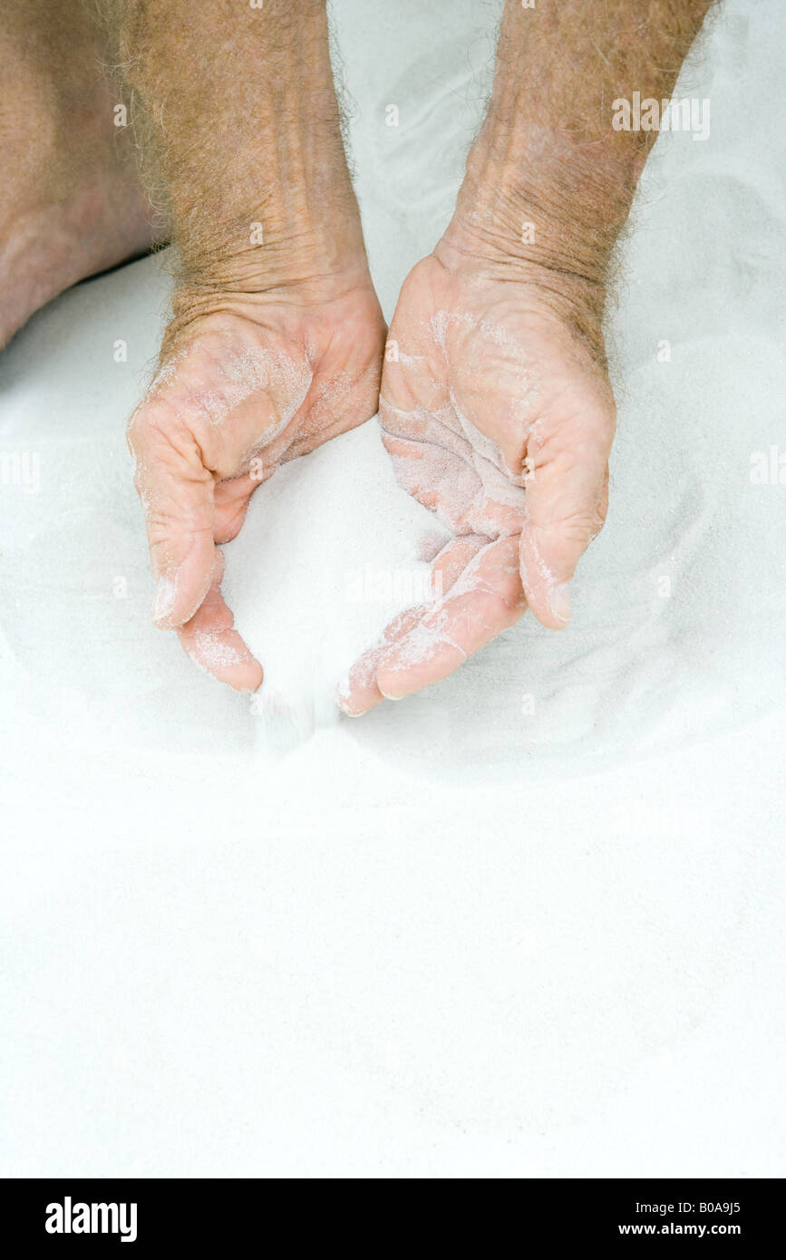 Man scooping sand in both hands, cropped view of hands Stock Photo - Alamy