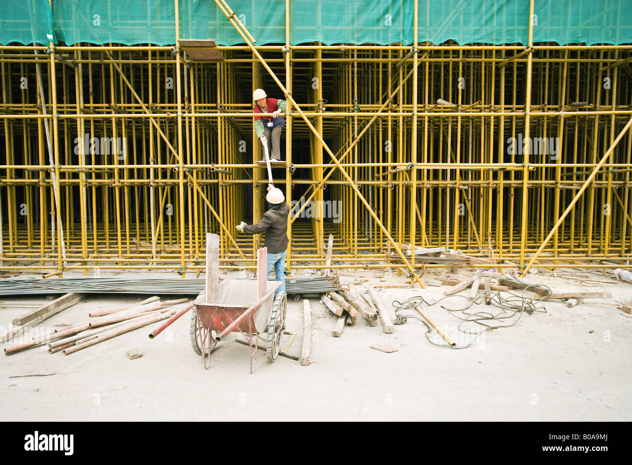 Two workers assembling scaffolding on construction site Stock Photo - Alamy