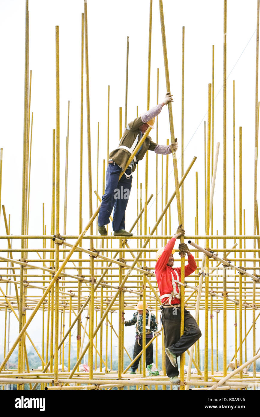 Workers assembling metal scaffolding at construction site Stock Photo ...