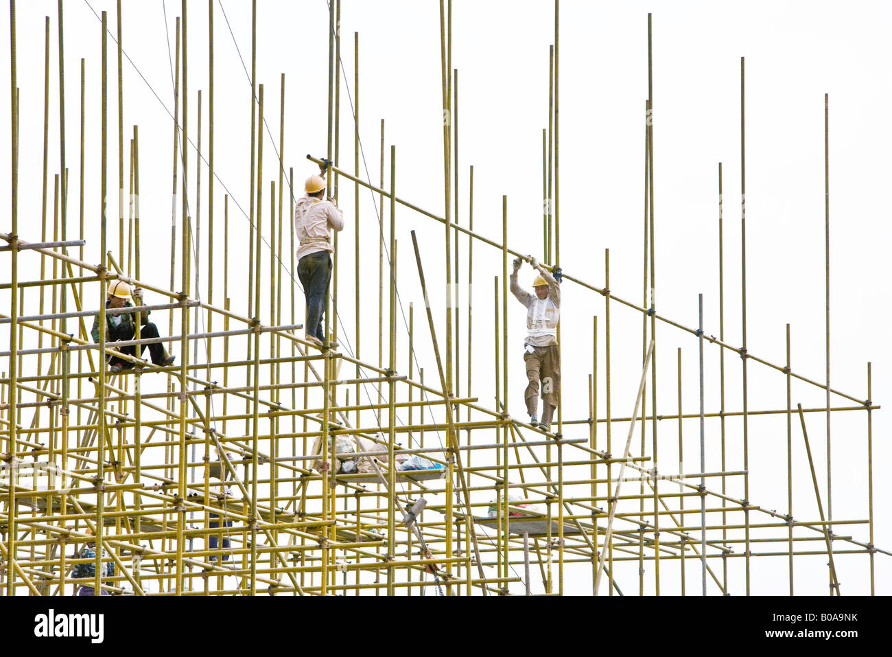 Workers building scaffolding at construction site Stock Photo - Alamy