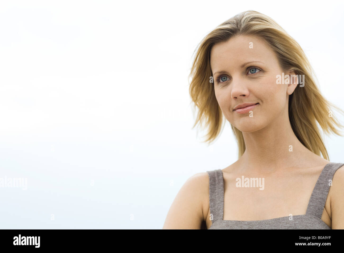 Blonde woman smiling, hair blowing in breeze, head and shoulders Stock ...