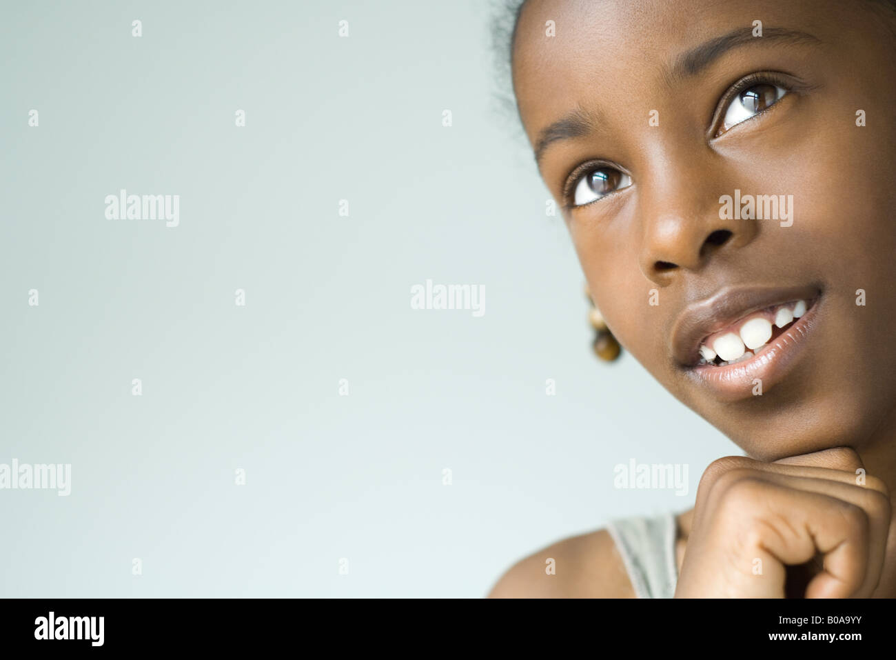 Little girl looking up, hand under chin, close-up, cropped Stock Photo ...
