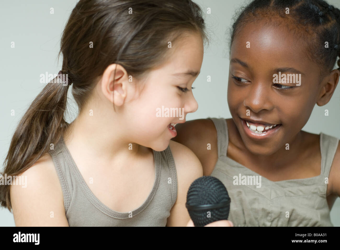 Two little girls singing into microphone, close-up Stock Photo - Alamy
