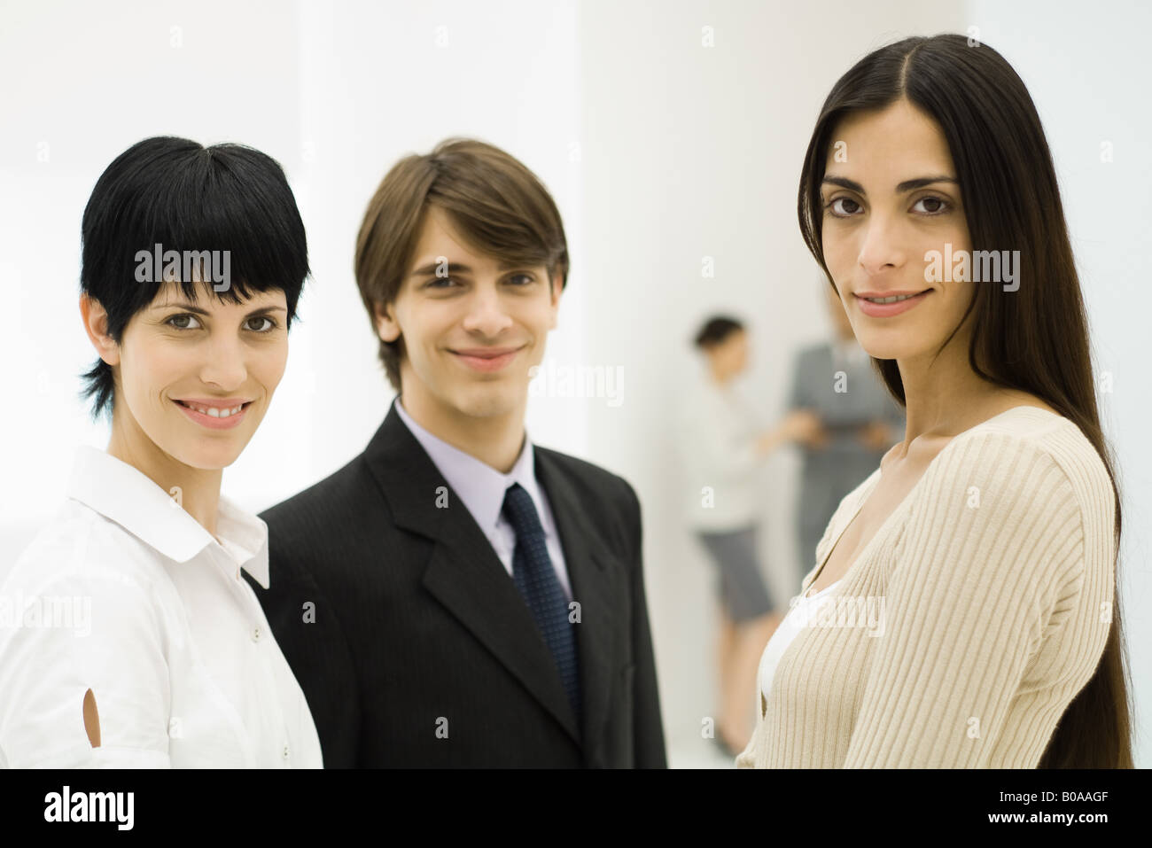 Three young professionals smiling at camera, close-up Stock Photo - Alamy