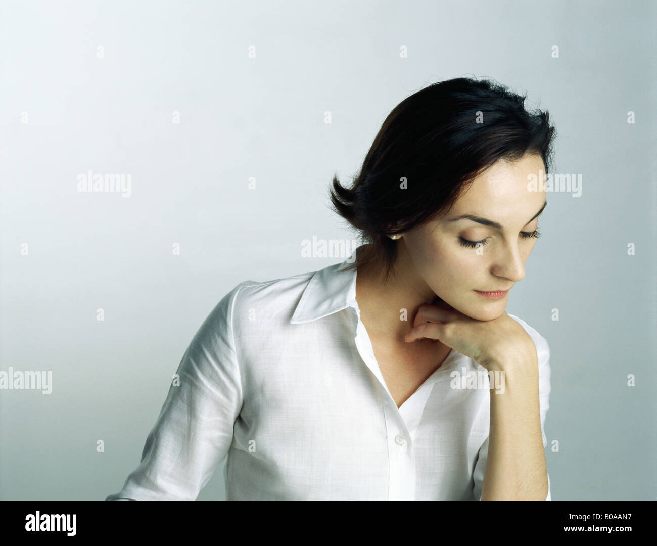 Woman resting chin on hand, looking down, portrait Stock Photo - Alamy
