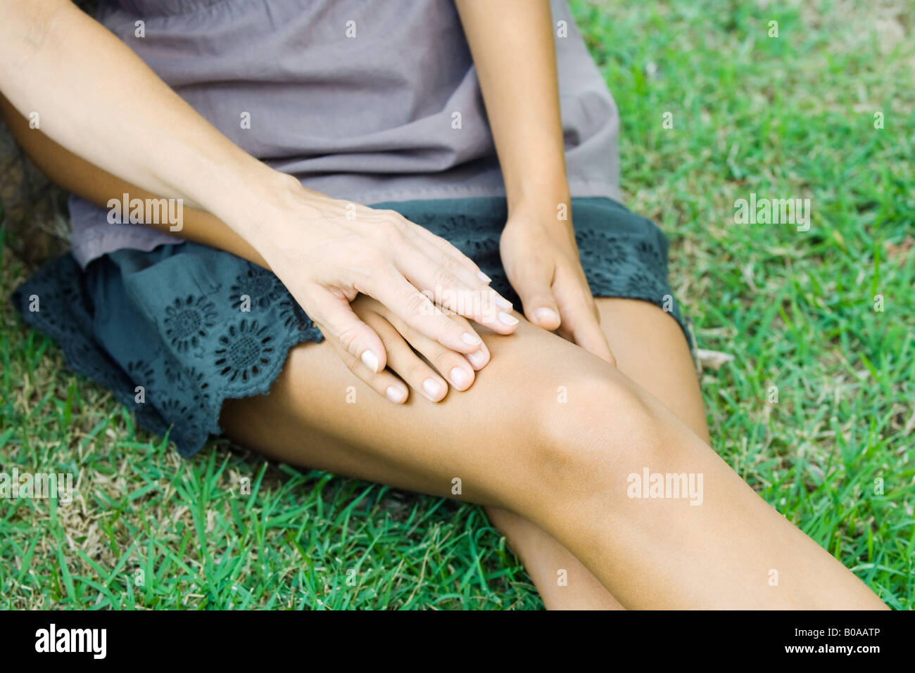 Female sitting on the ground, holding woman's hand, cropped view Stock ...