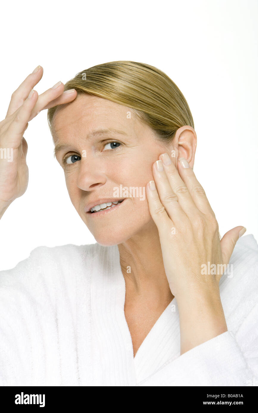 Woman touching forehead and cheek, close-up Stock Photo - Alamy