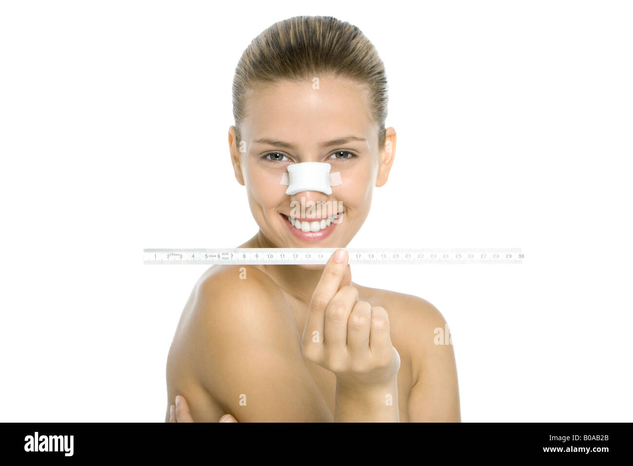Woman with bandaged nose, holding measuring tape, smiling at camera ...