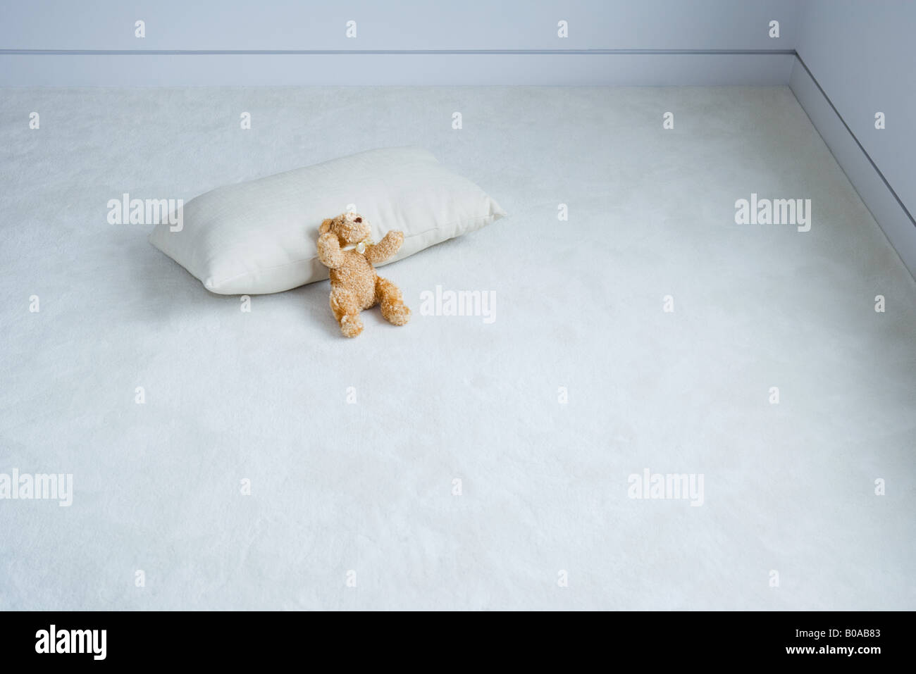 Teddy bear resting against cushion Stock Photo - Alamy