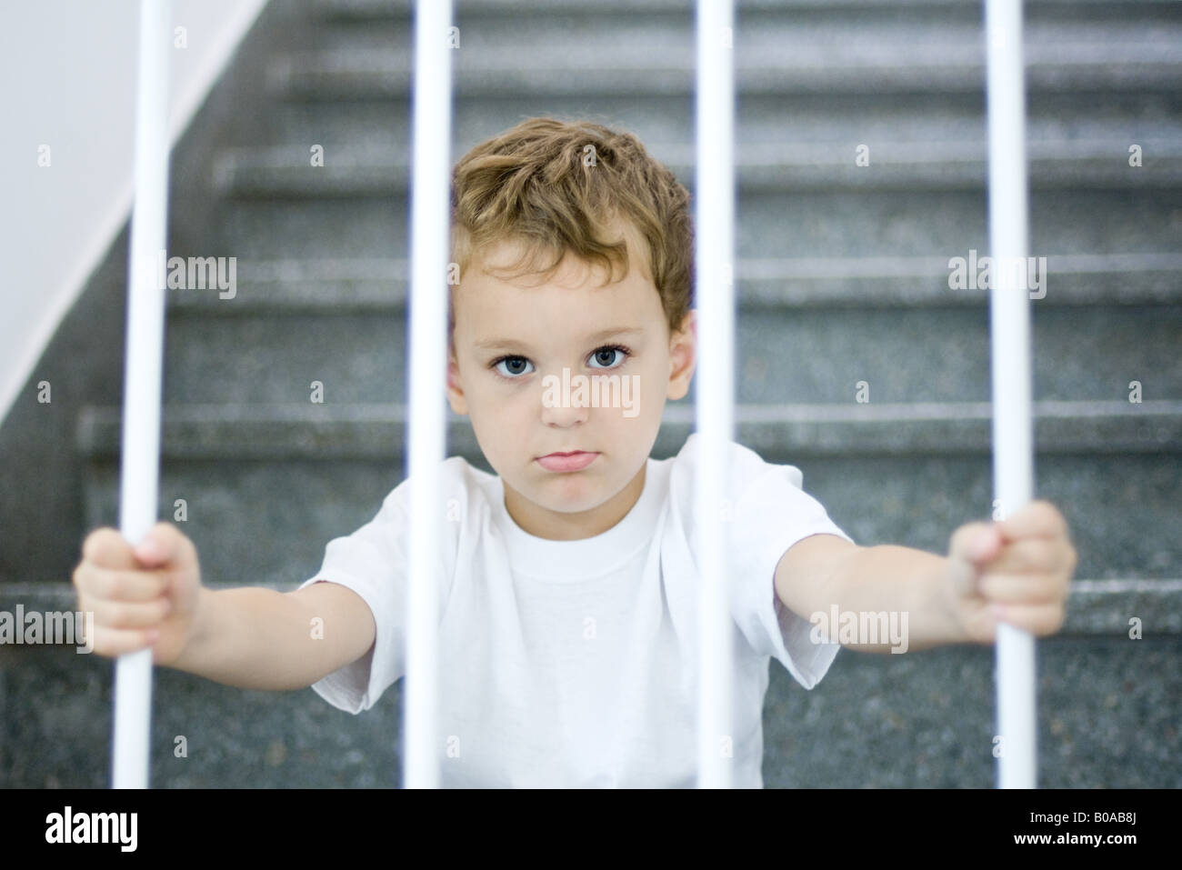 Little boy behind bars, looking at camera Stock Photo - Alamy