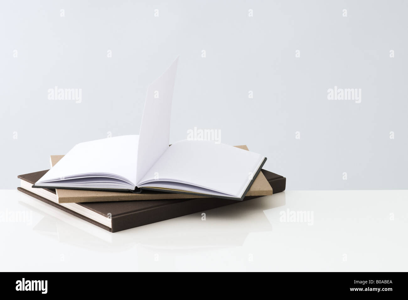 Stack of books, one open book with blank pages inside Stock Photo - Alamy