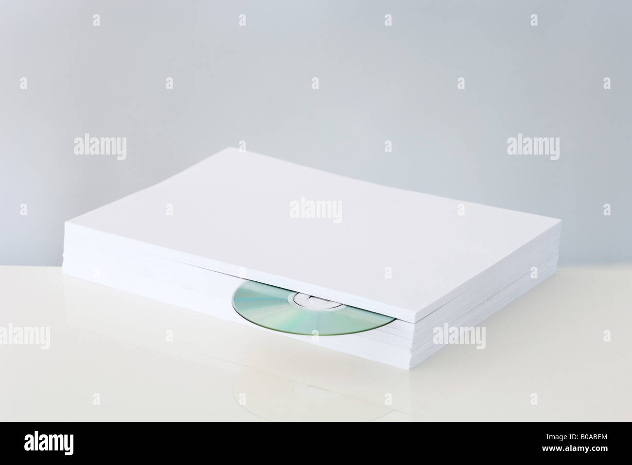 CD emerging from stack of paper Stock Photo - Alamy