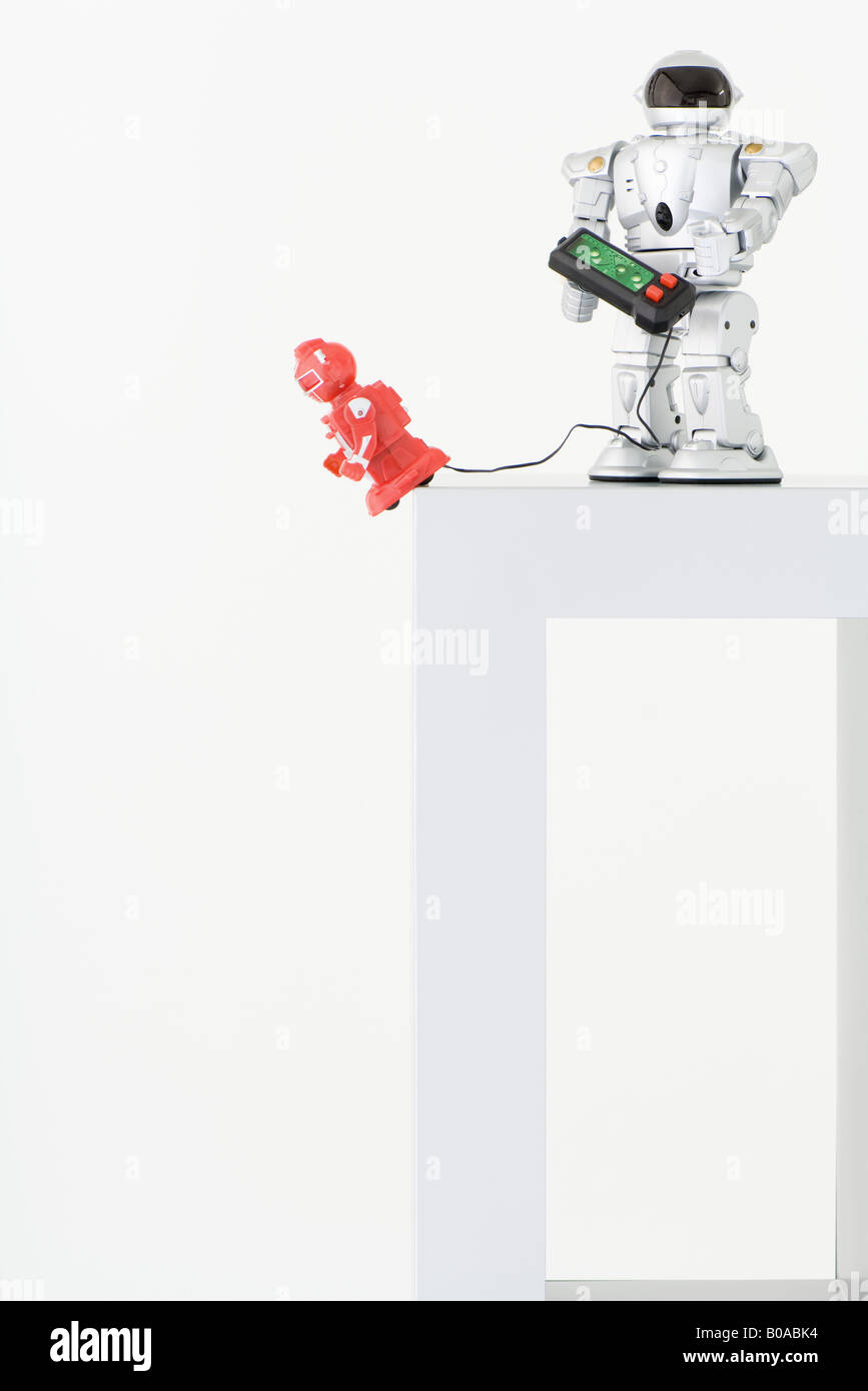 Robot playing with smaller remote control robot Stock Photo - Alamy