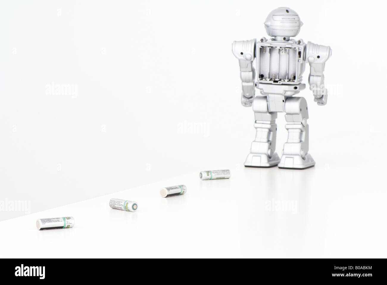 Robot leaving trail of batteries behind it Stock Photo - Alamy