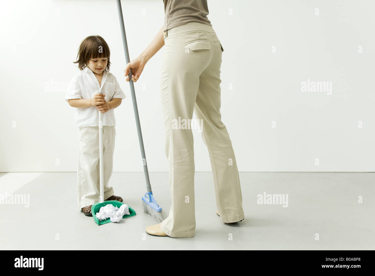Little boy helping his mother sweep the floor, cropped view Stock Photo ...