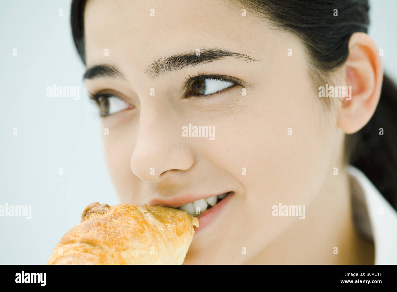 Young woman eating croissant, close-up Stock Photo - Alamy