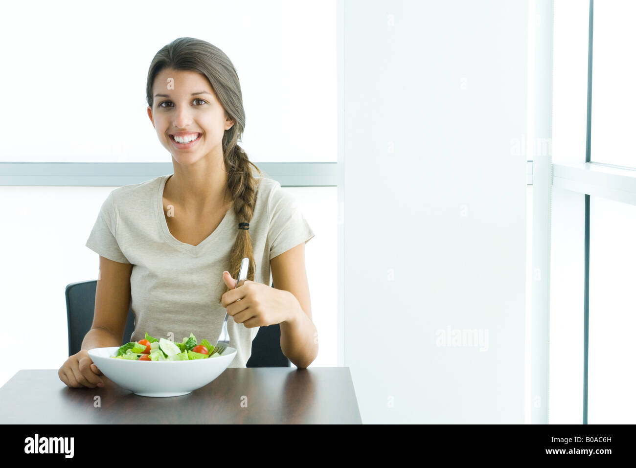 Teen girl eating salad, smiling at camera Stock Photo - Alamy