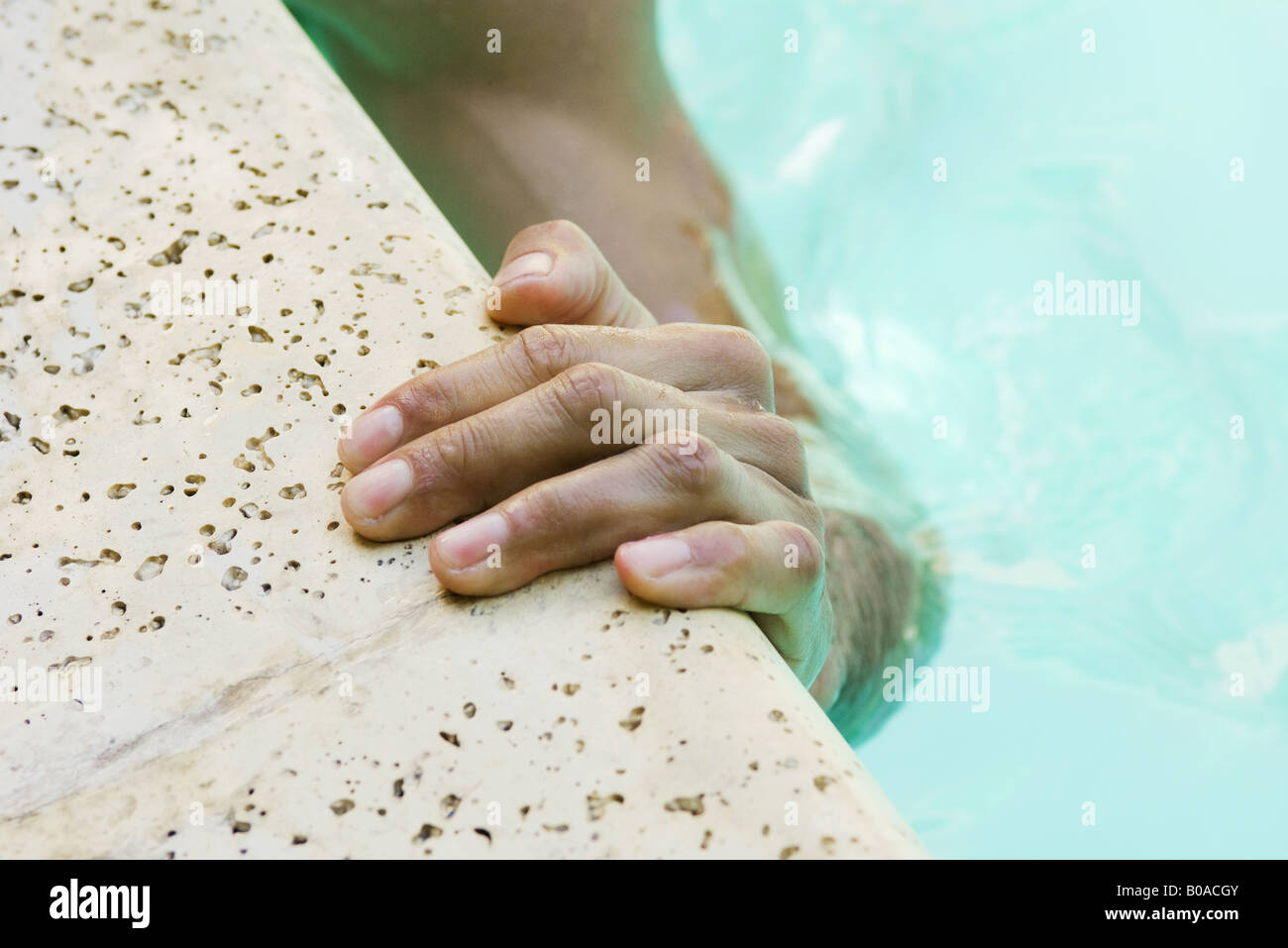 Man holding on to edge of swimming pool, cropped view of hand Stock ...