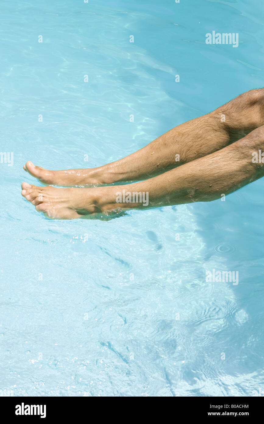 Man dipping feet in swimming pool, cropped view Stock Photo - Alamy