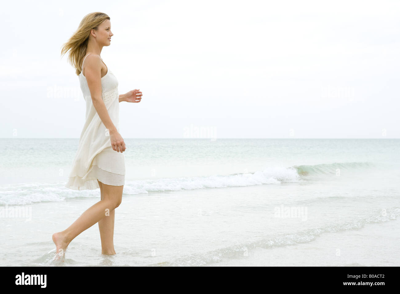 Woman walking at the beach, side view Stock Photo - Alamy
